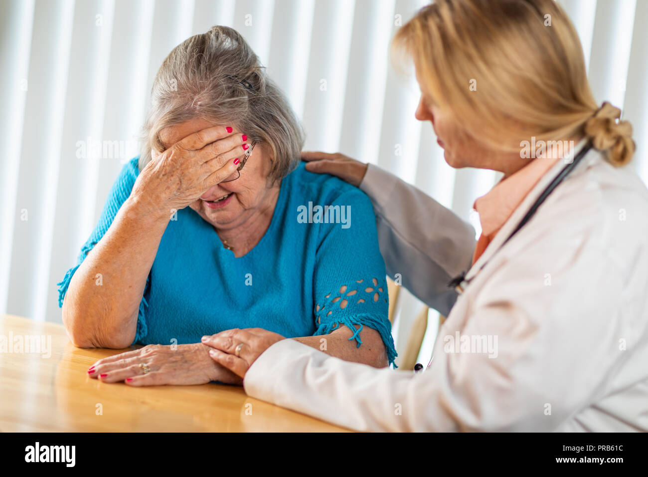 Female Doctor Consoling Distraught Senior Adult Woman Stock Photo - Alamy