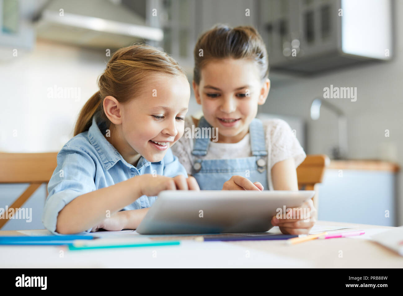 Two little girls having fun while watching curious vids or cartoons in ...