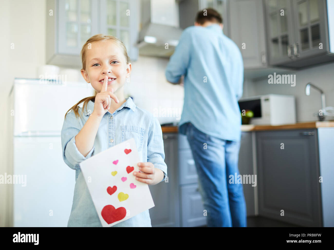 Happy girl with greeting card making shh gesture before congratulating ...