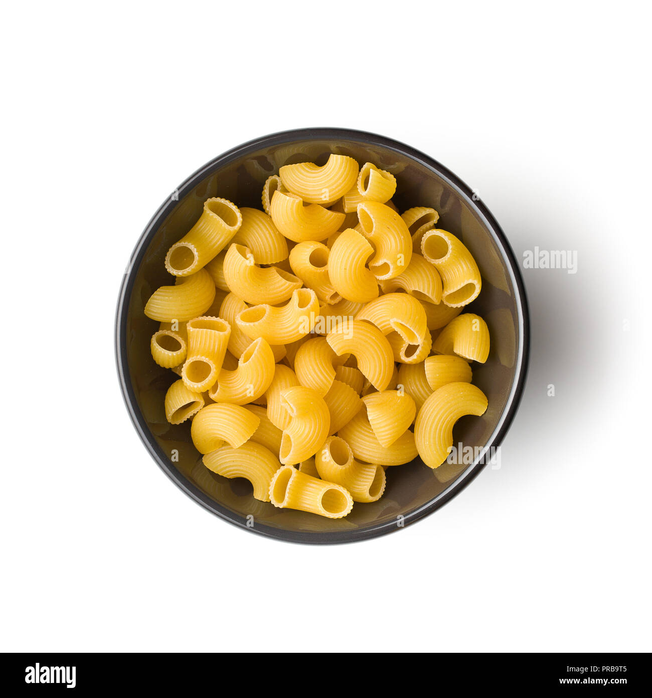 Uncooked elbow macaroni in bowl isolated on white background Stock ...