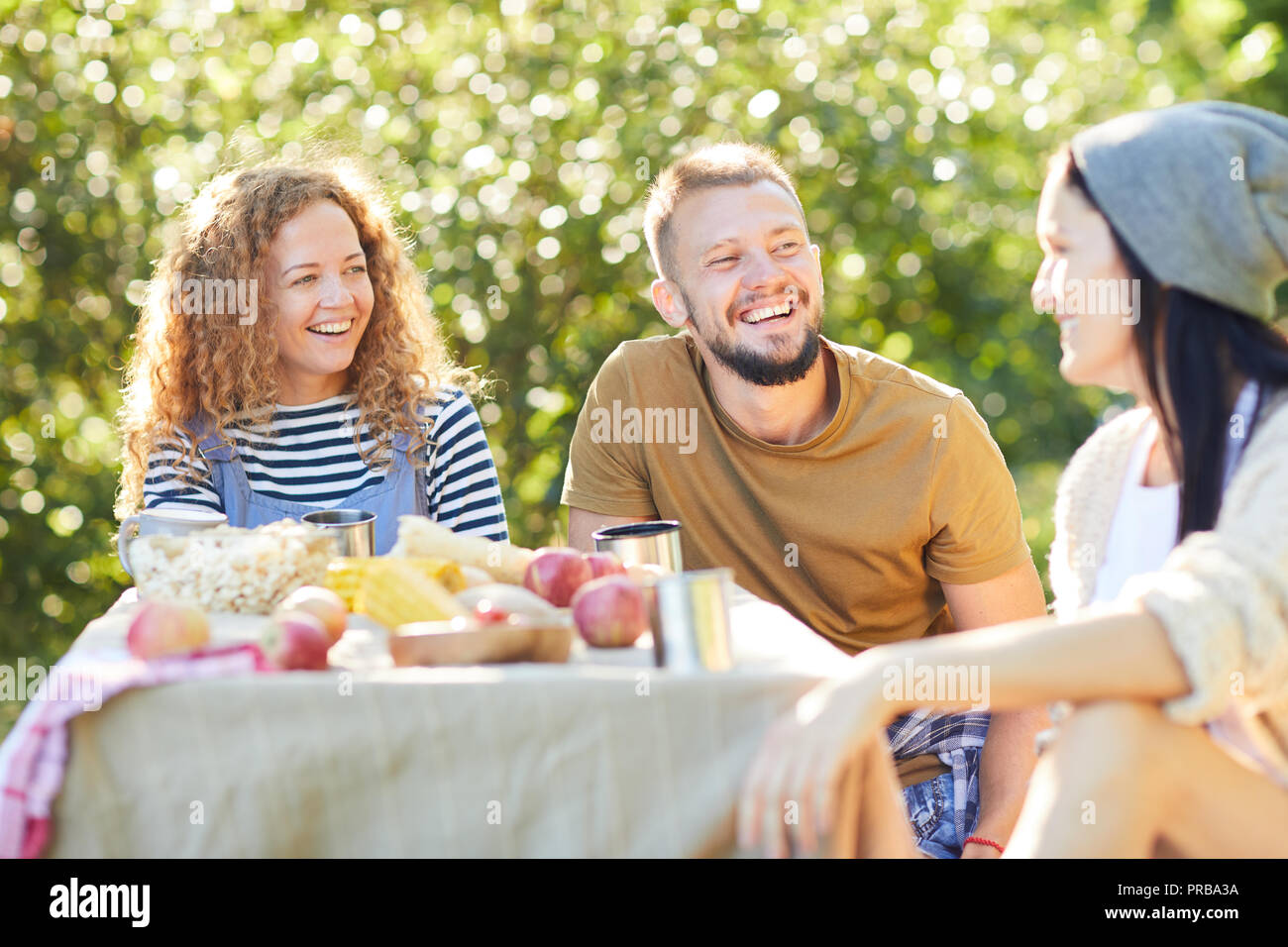 Three young people laughing while discussing something funny by served ...