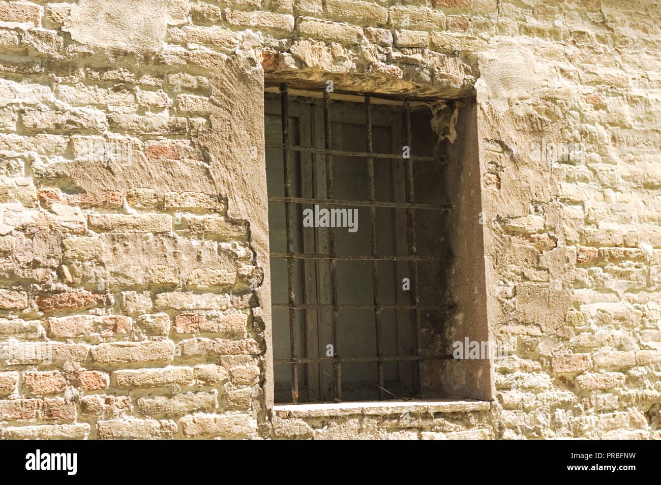 Isolated medieval window with iron gratings (Marche, Italy, Europe ...