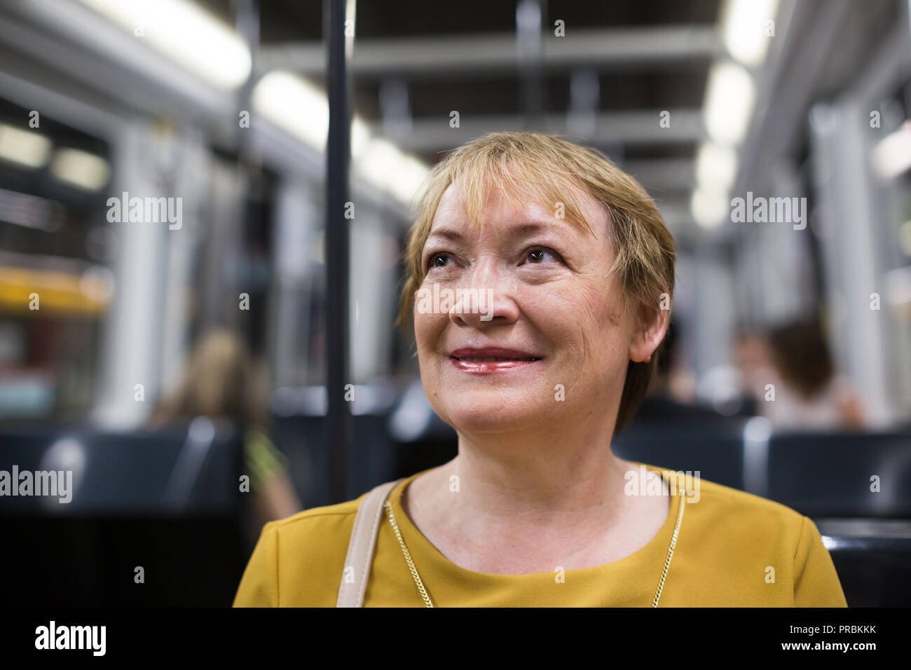 Smiling senior woman commuter taking journey in public train Stock ...