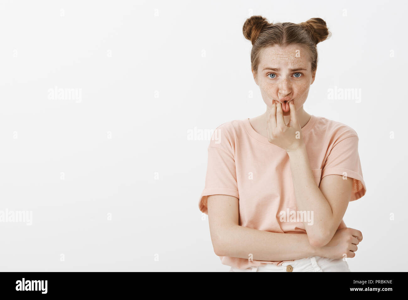 Girl making faces while feeling perplexed, thinking what decision right ...