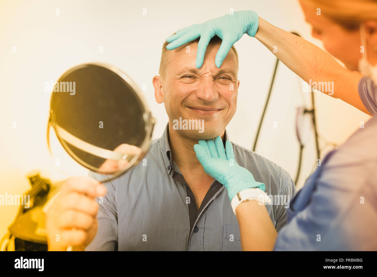 Woman doctor is examining patient behind mirror before the procedure in ...