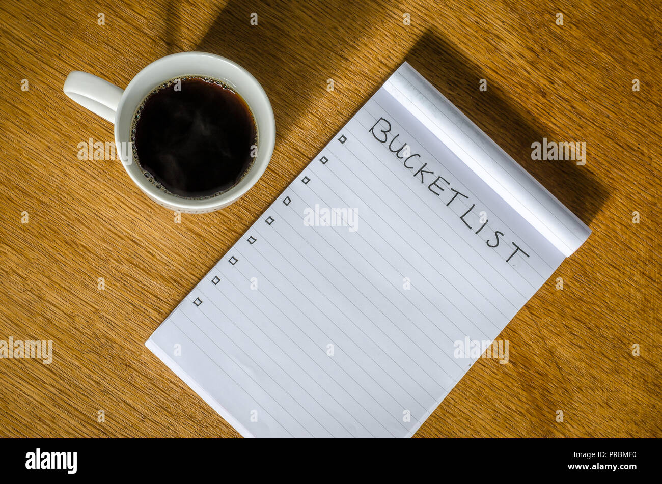 Bucket list on a block note with a wooden backgrond Stock Photo - Alamy