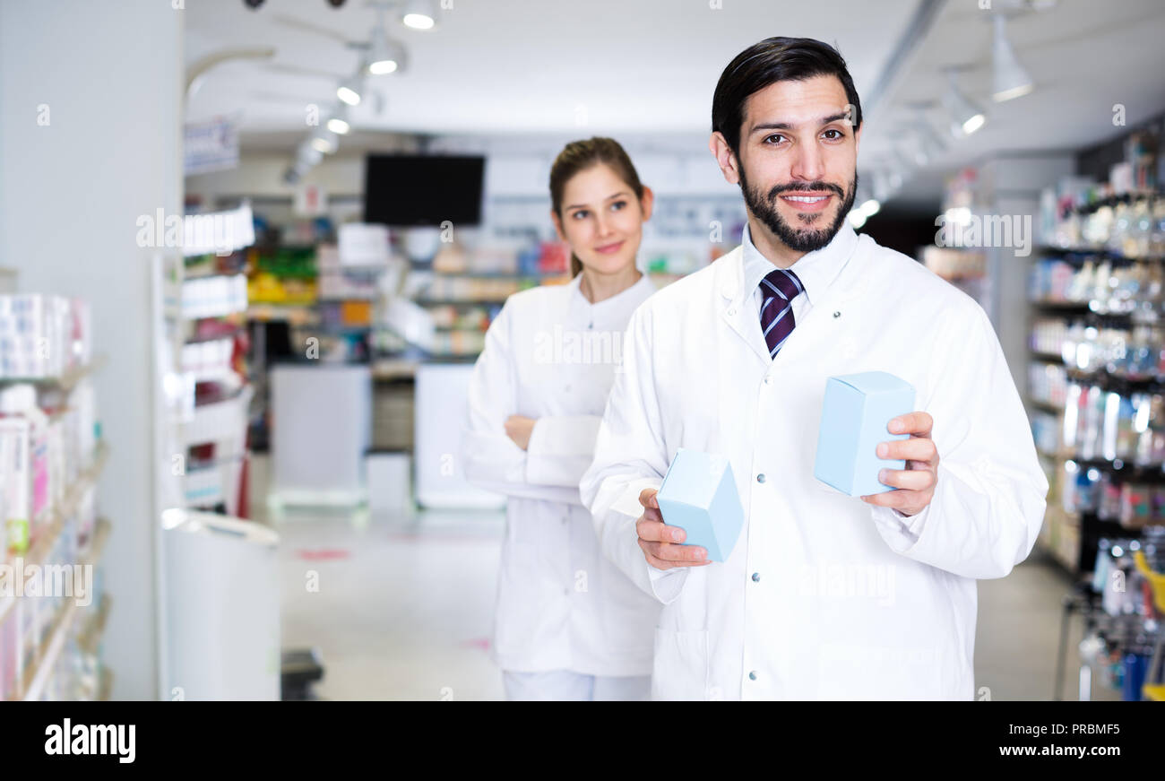 Positive male pharmacist is standing with medicines in pharmacy Stock ...