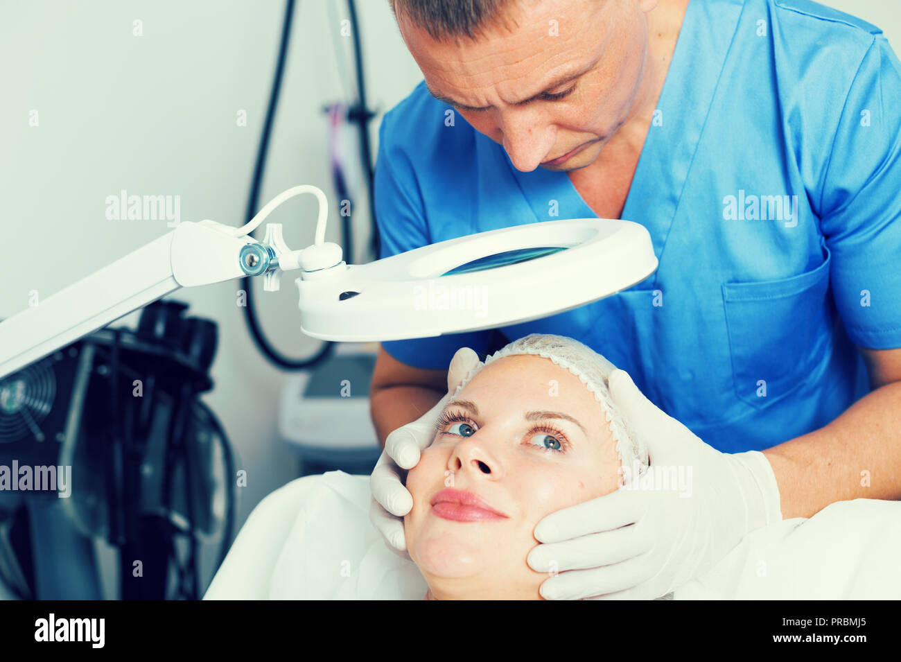 Specialist is analysing skin of female patient with using magnification ...
