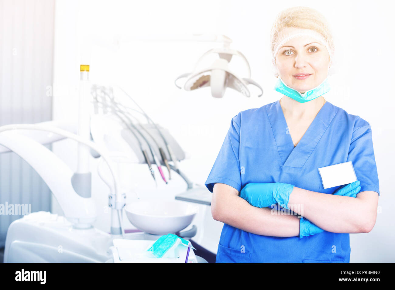 Portrait of professional woman dentist posing with arms crossed at ...