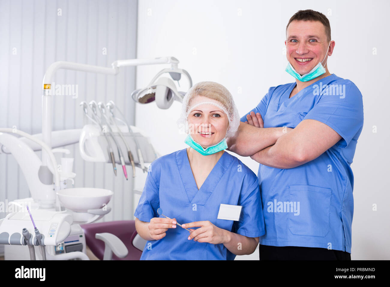 Two successful smiling professional dentists posing at modern dental ...
