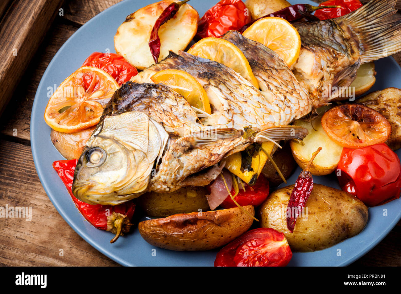Delicious roasted fish with lemon and garnish Stock Photo - Alamy