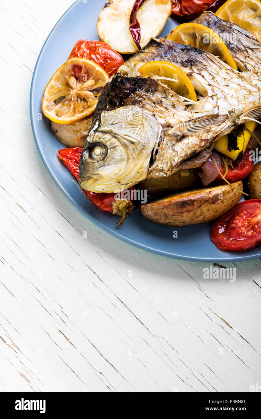 delicious roasted fish with lemon and garnish Stock Photo - Alamy