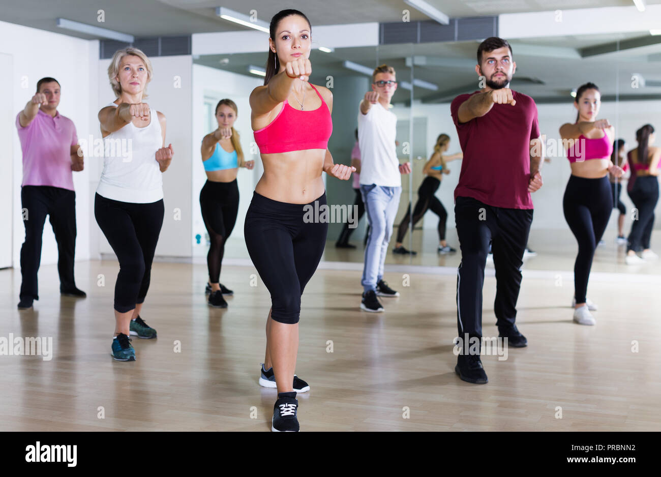Glad people of different ages studying sport dance elements in dancing ...
