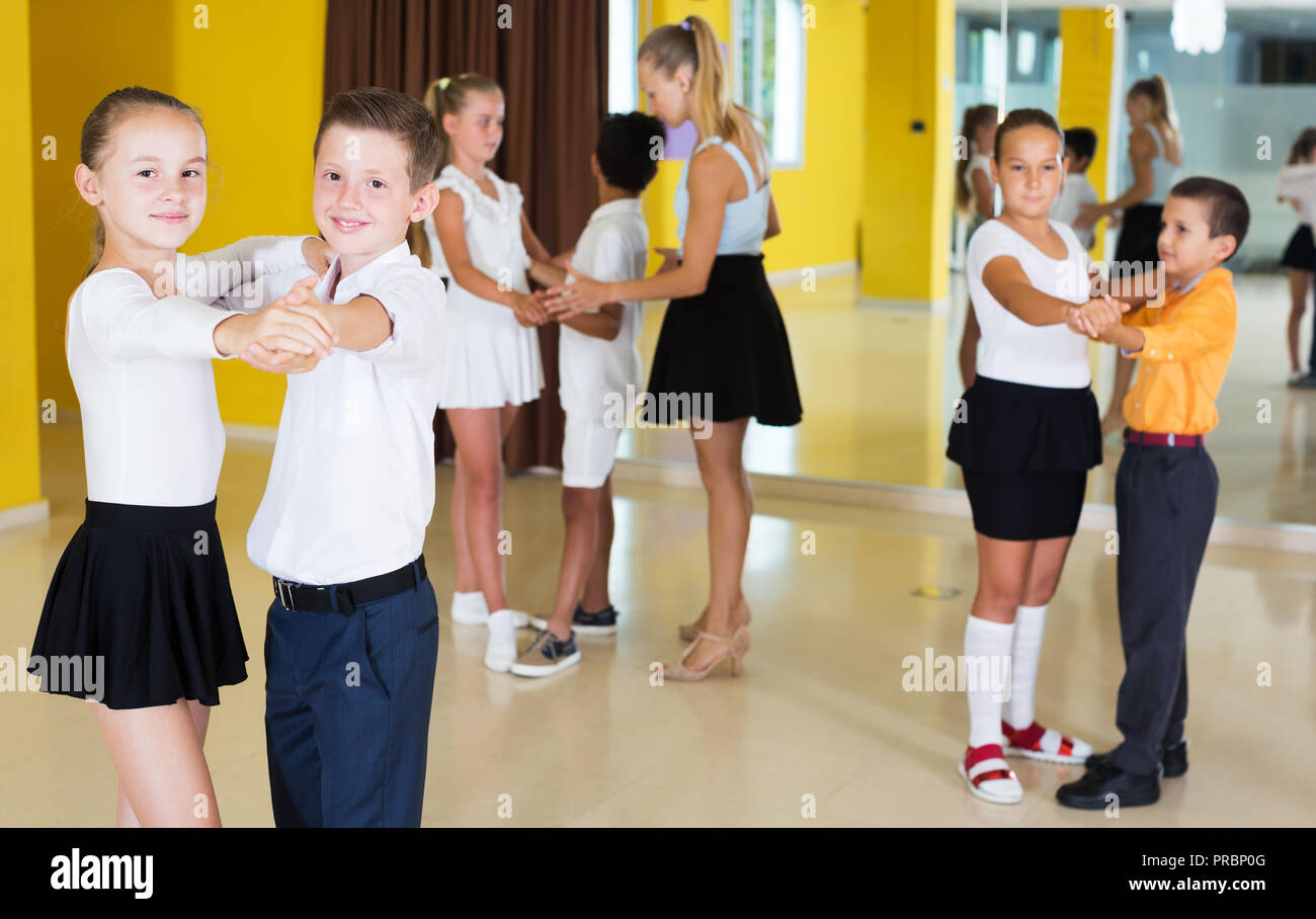Children in dance studio examining new movements, smiling and having ...