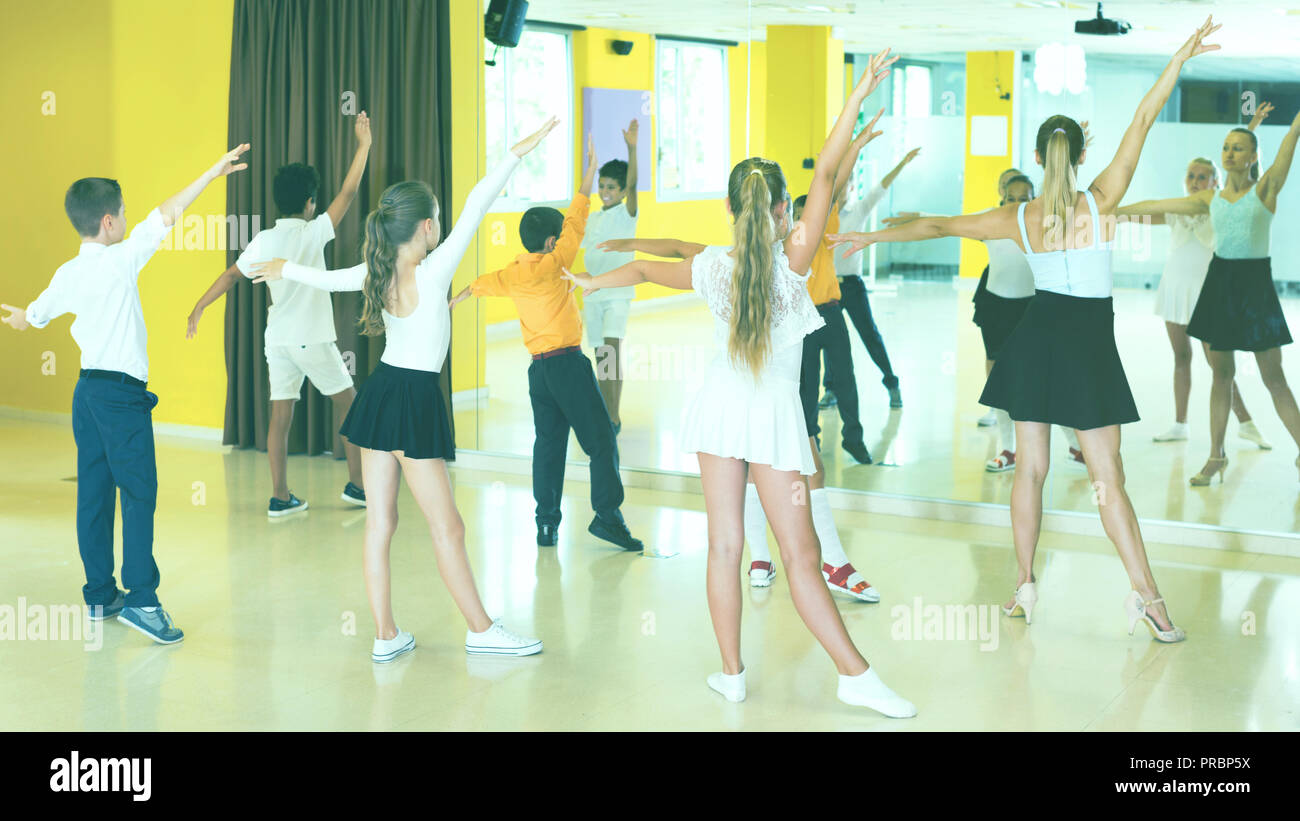 Friendly smiling positive children learn dance movements in dance class ...