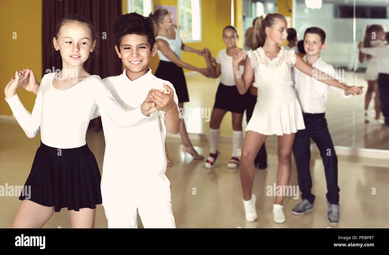 Friendly positive little boys and girls having dancing class in ...