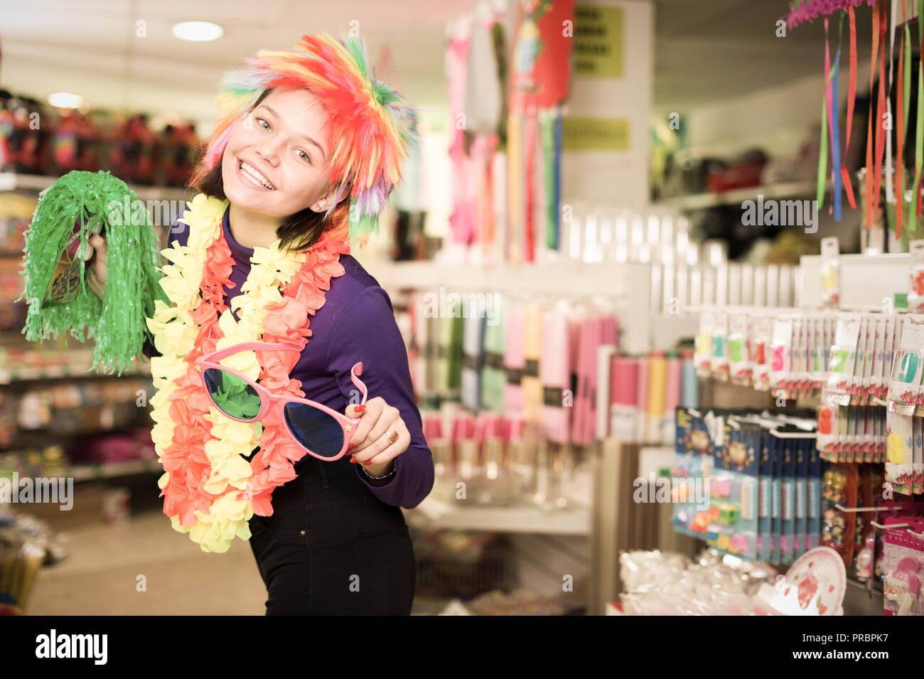 Positive girl looking for funny things in store of festival outfits and ...