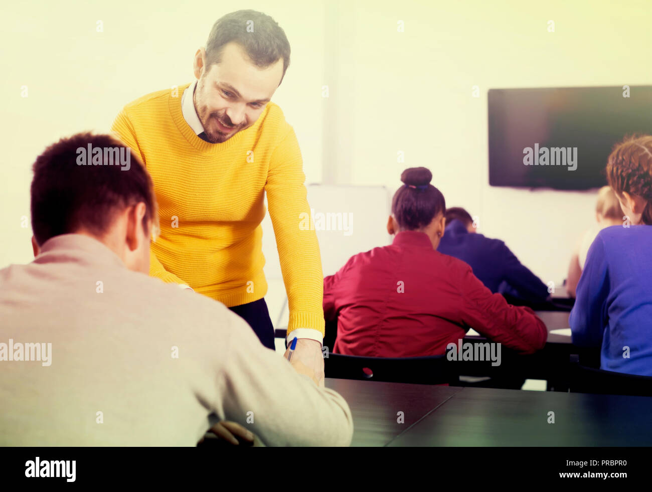 happy spanish male teacher clearing up complicated issue to pupil ...