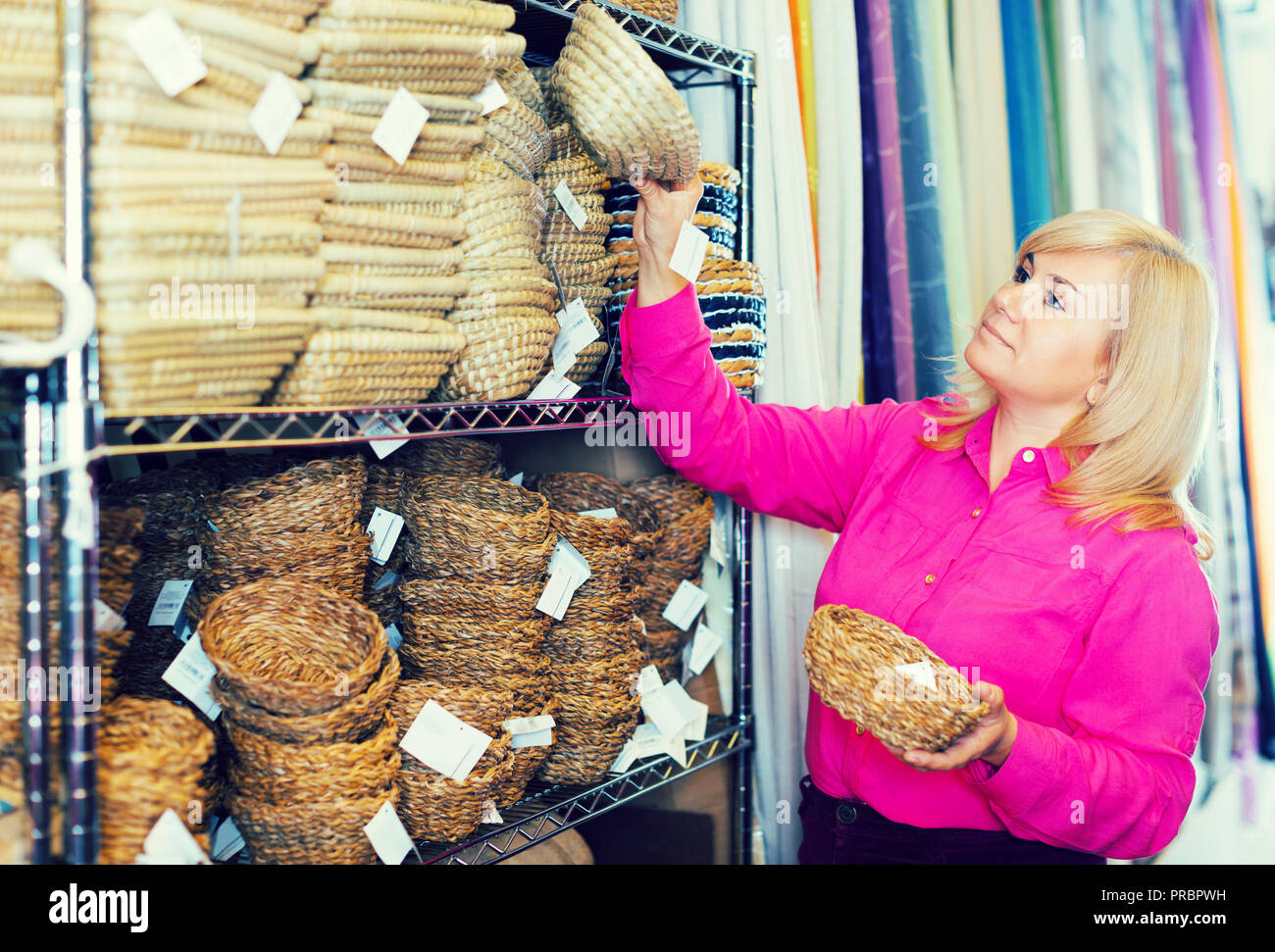 mature customer standing with wicker basket in store for decor Stock ...