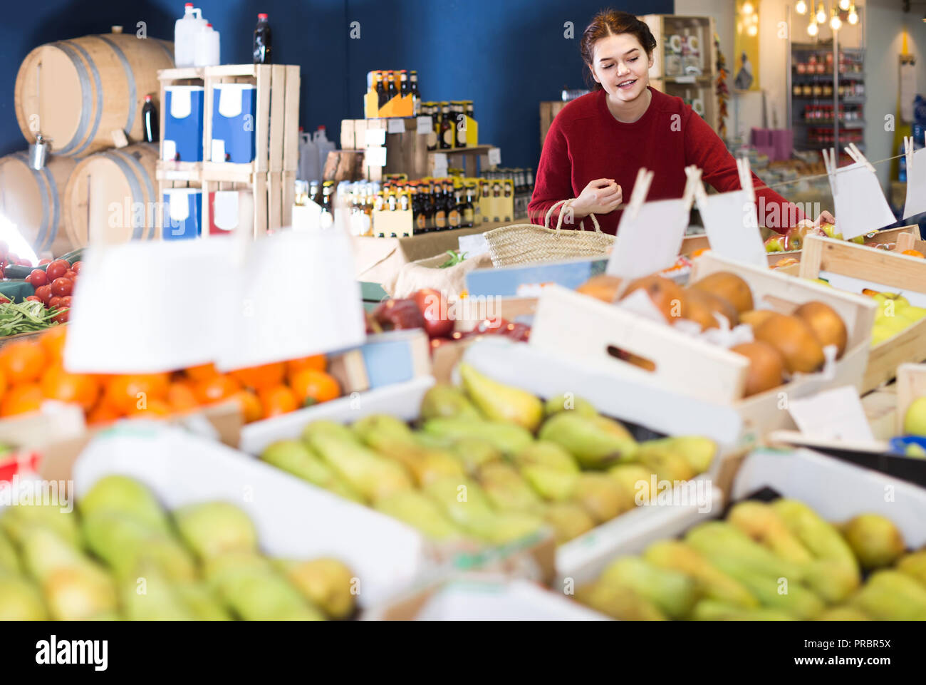 portrait of happy american young customer selecting apple in grocery ...