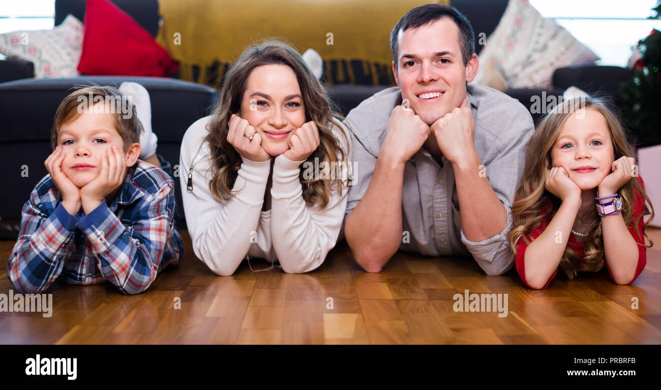 cheerful parents and two kids happy to spend time together at home ...