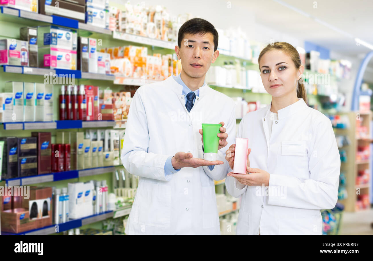 Portrait of two pharmacists who are standing with medicine on their ...