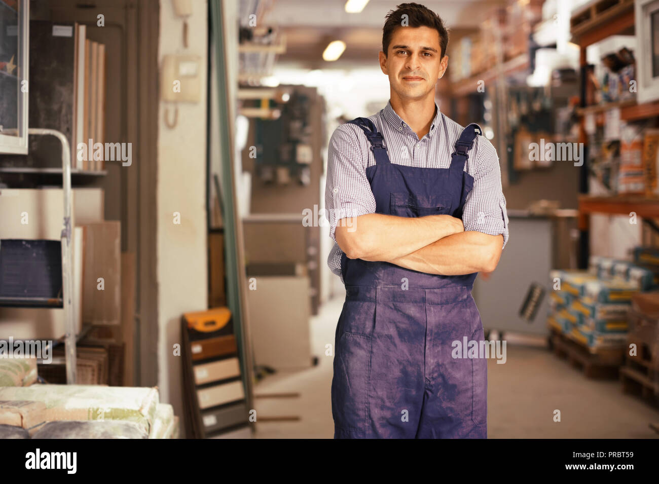 Portrait of smiling working man in uniform on his workplace in building ...