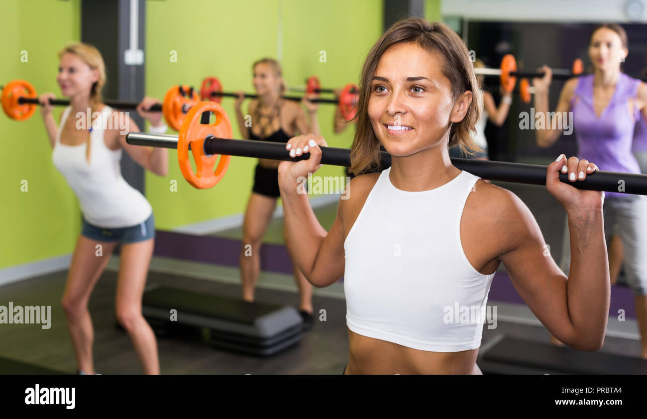 happy italian athletic girls during workout in gym with barbell Stock ...
