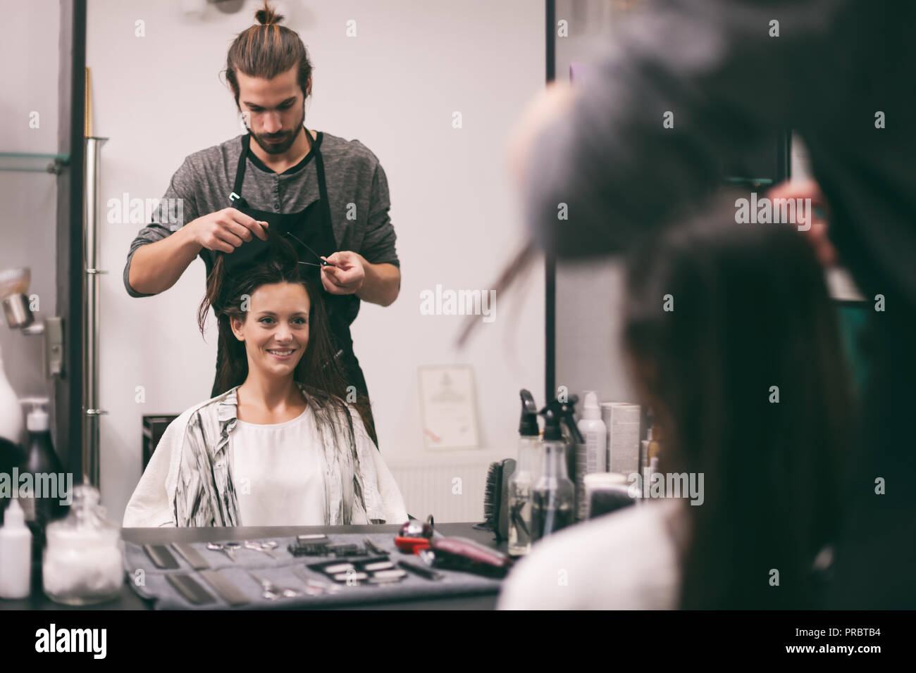 Young woman getting new hairstyle at professional hair styling saloon ...