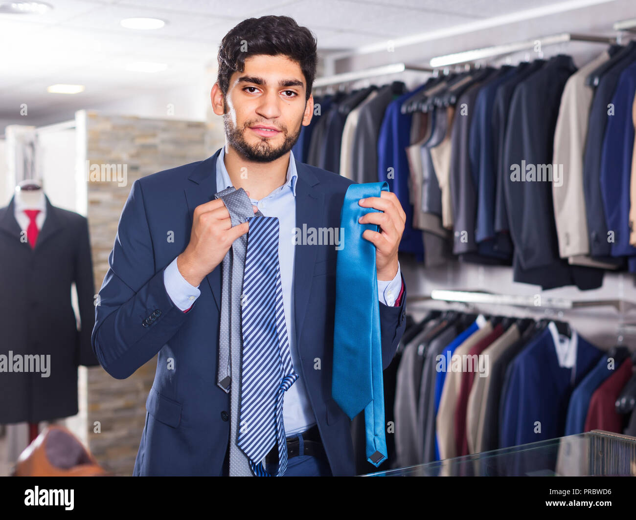 Shopper is picking up tie for suit in men's shop Stock Photo - Alamy