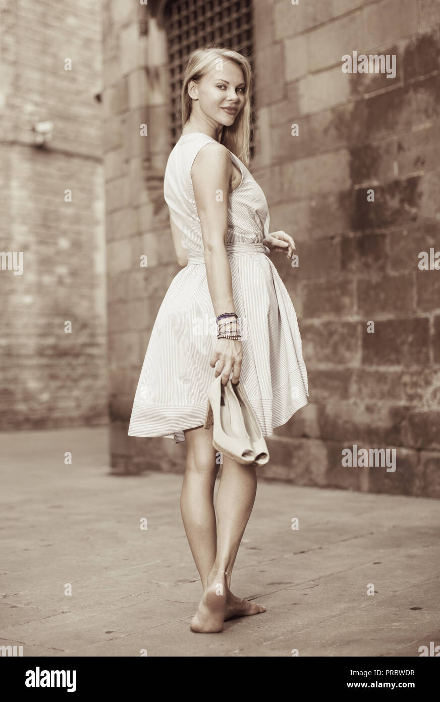 Positive female in the dress walking without shoes in summer Stock ...