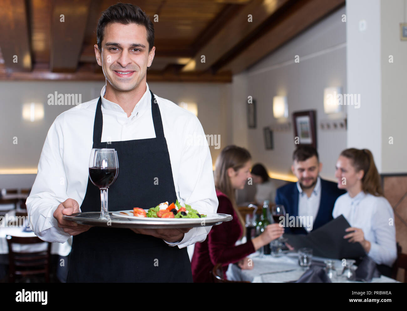 Handsome waiter with serving tray welcoming to restaurant Stock Photo ...