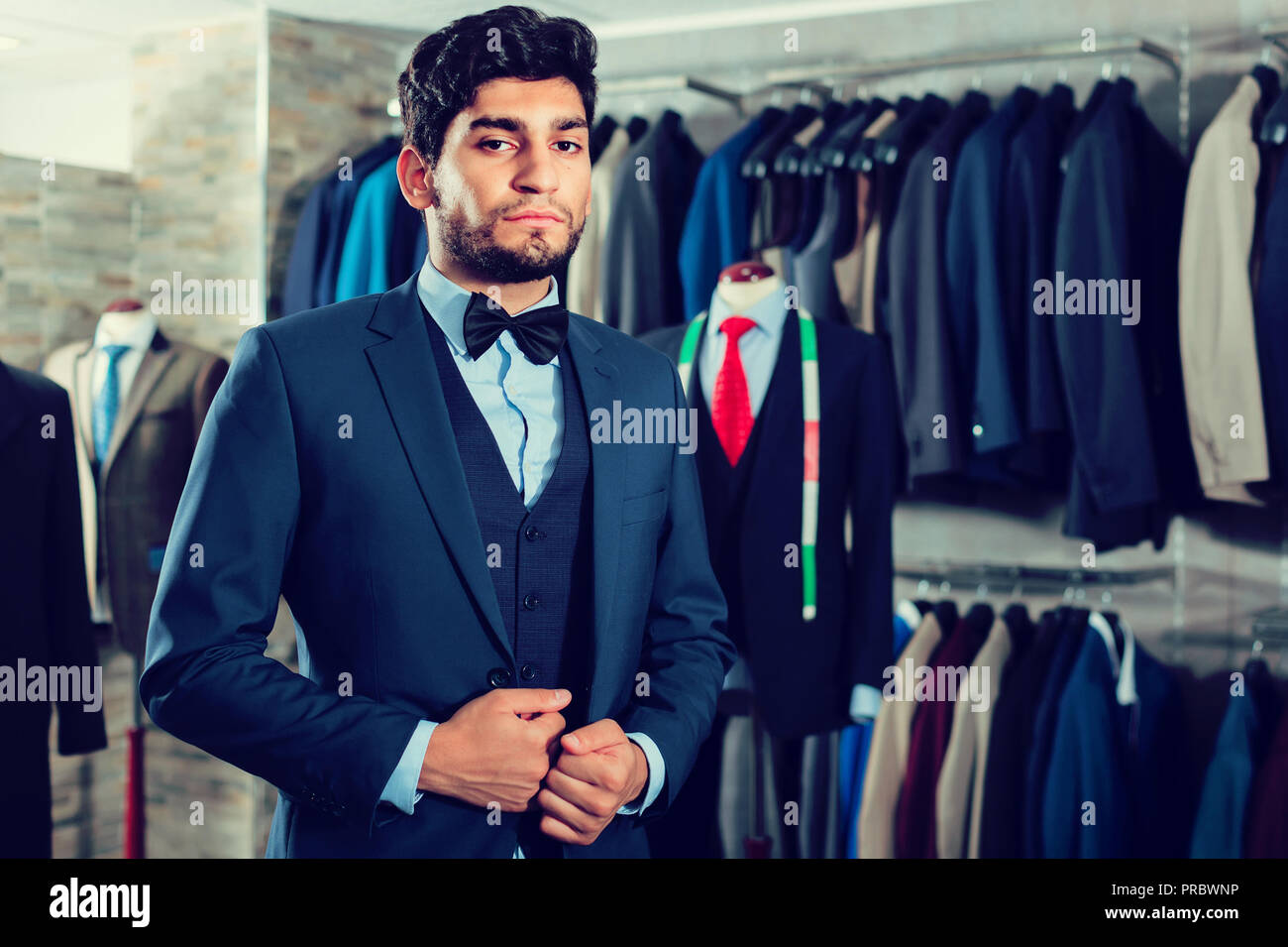 Shopper is demonstrating his choice of suit with jacket in shop Stock ...