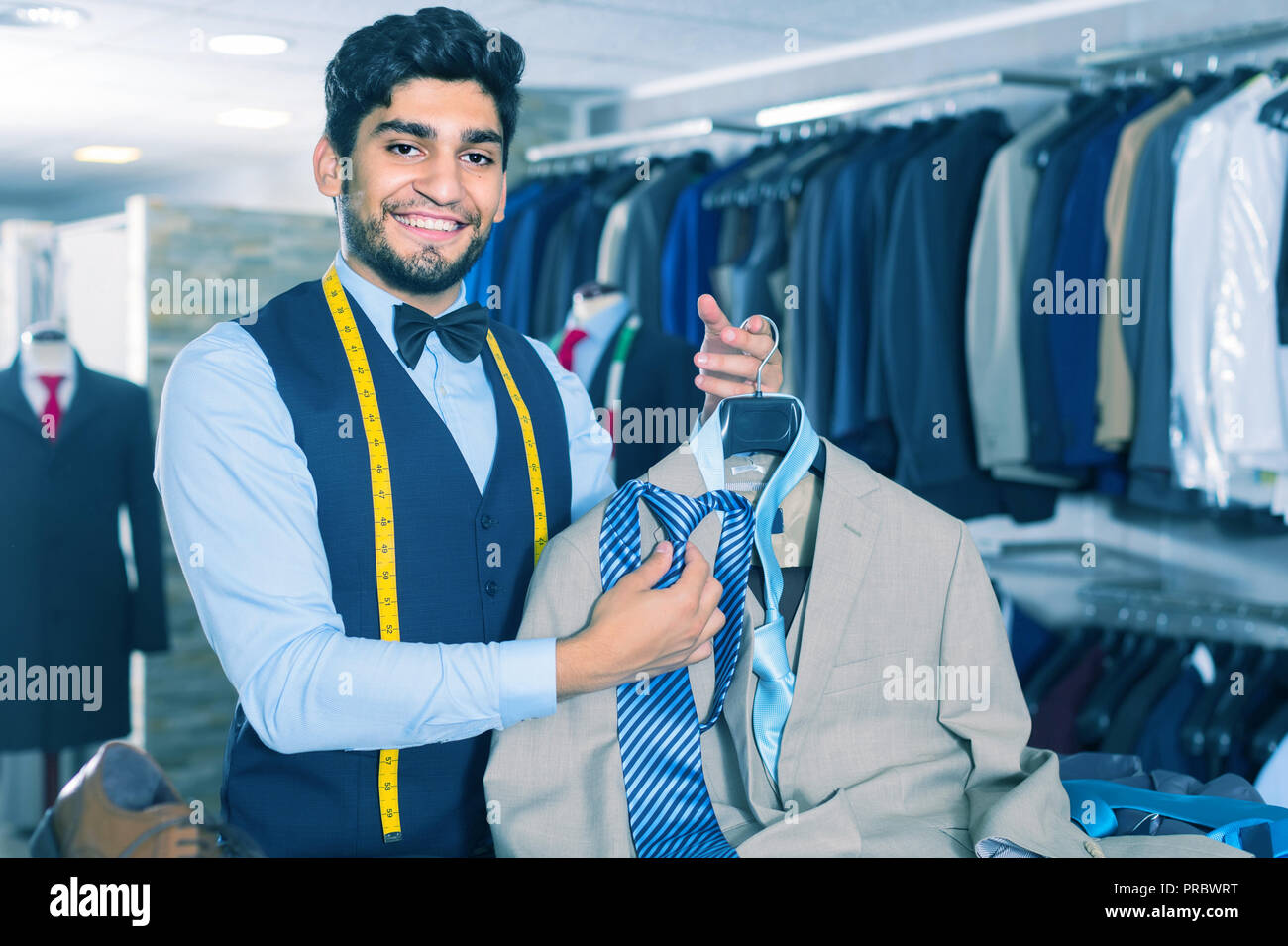 Salesman is picking up a tie for light jacket in the shop Stock Photo ...