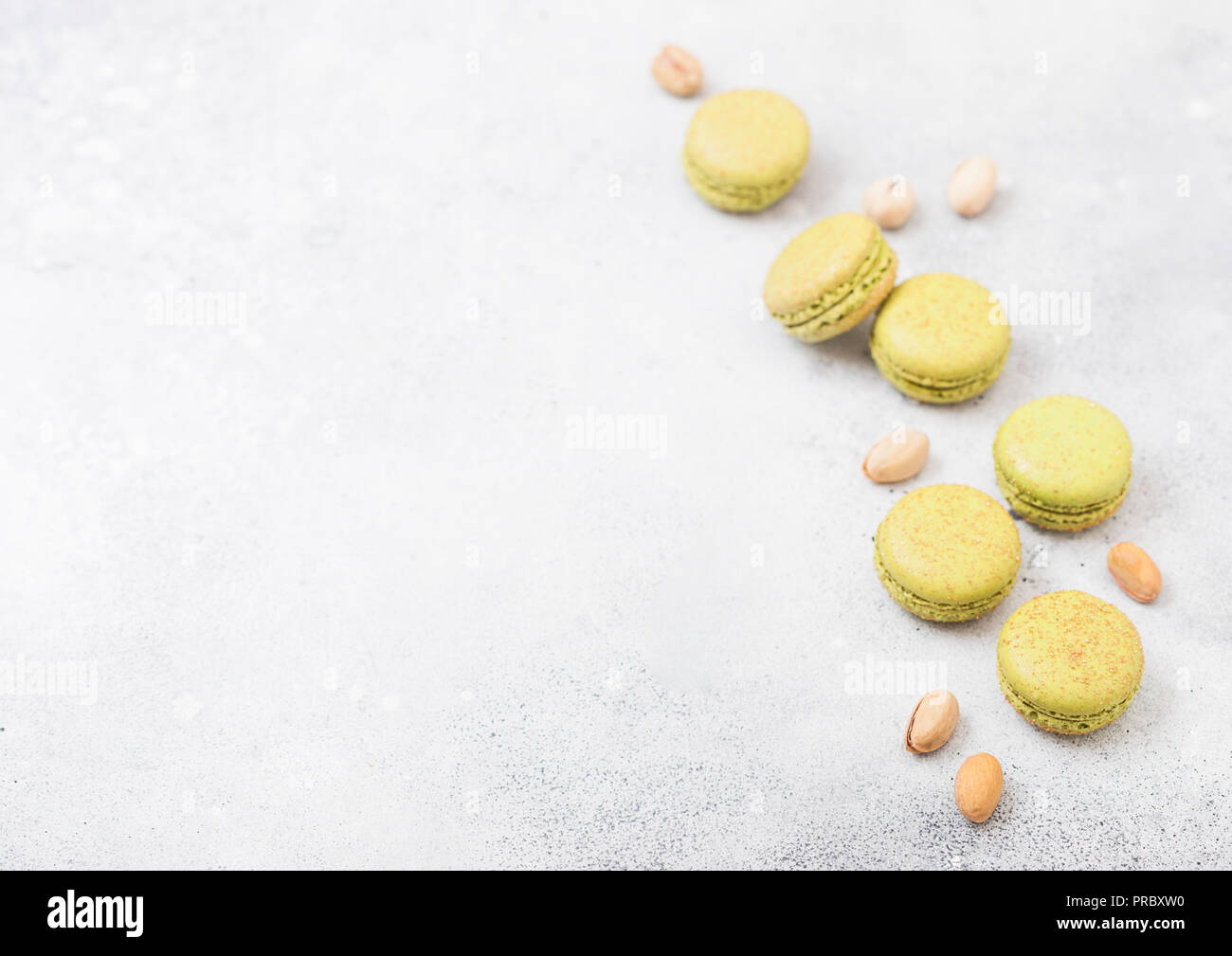 Green dessert cake macaron or macaroon with pistachio nuts on stone ...