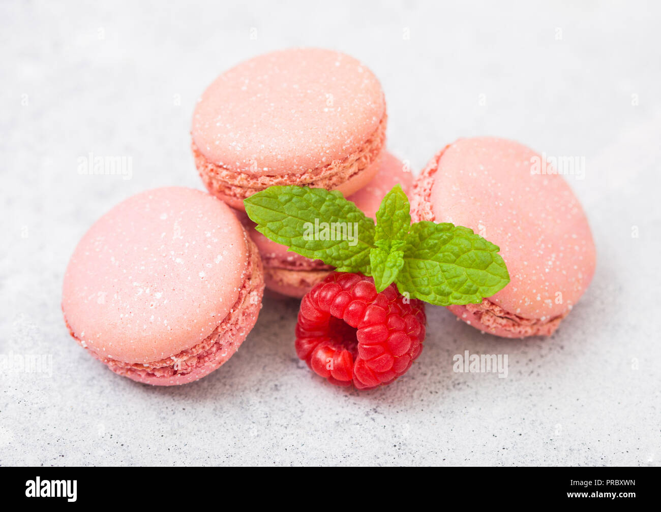 Pink dessert cake macaron or macaroon with raspberry and mint leaf on ...