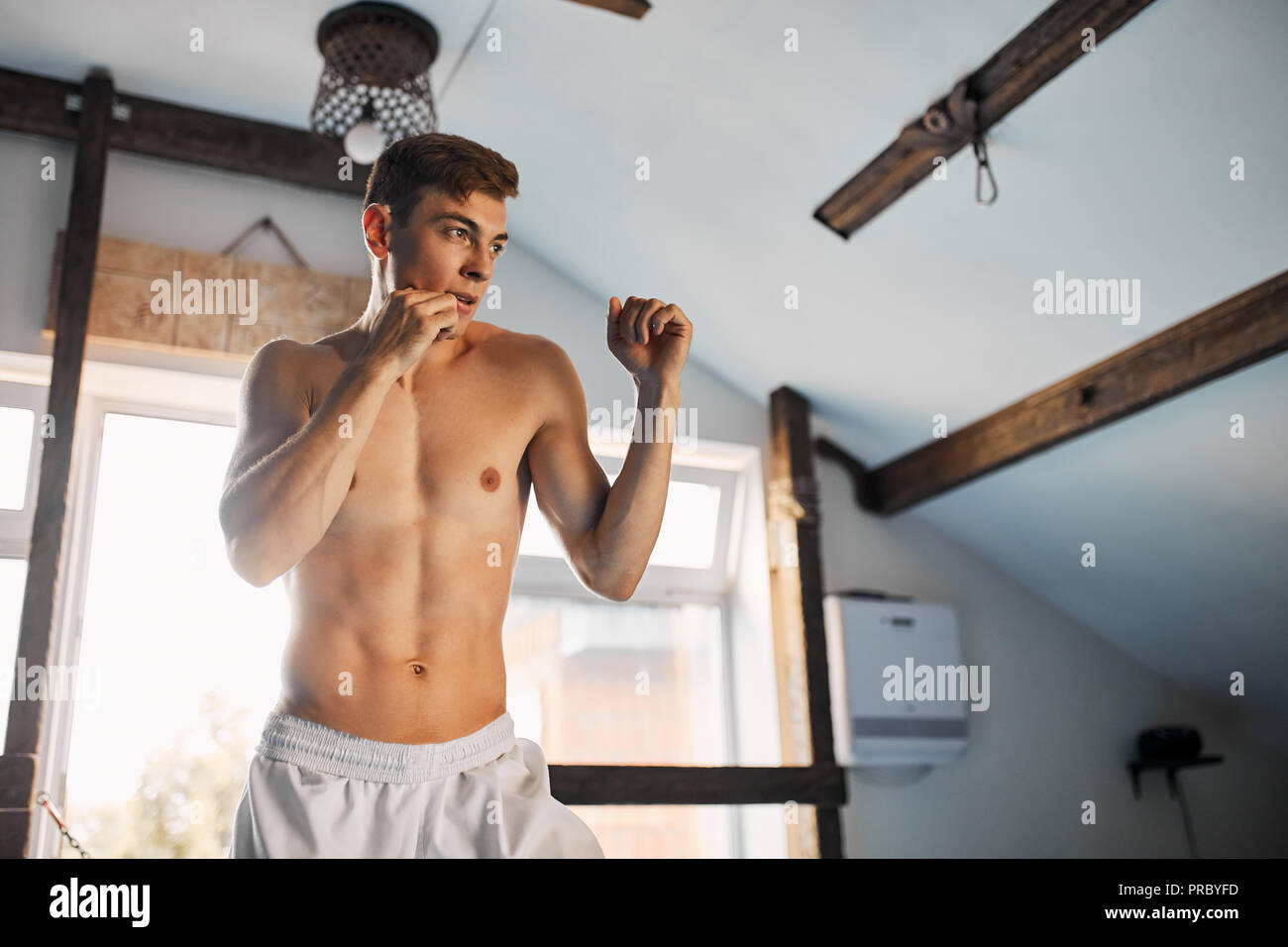 Man in white kimono with black belt training karate in gym Stock Photo ...