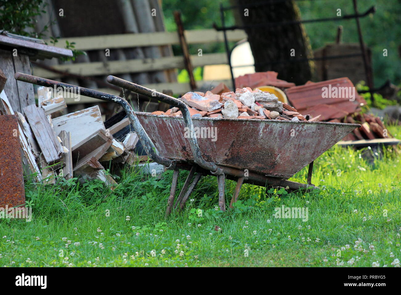 Fully loaded with construction material rusted used wheelbarrow ...