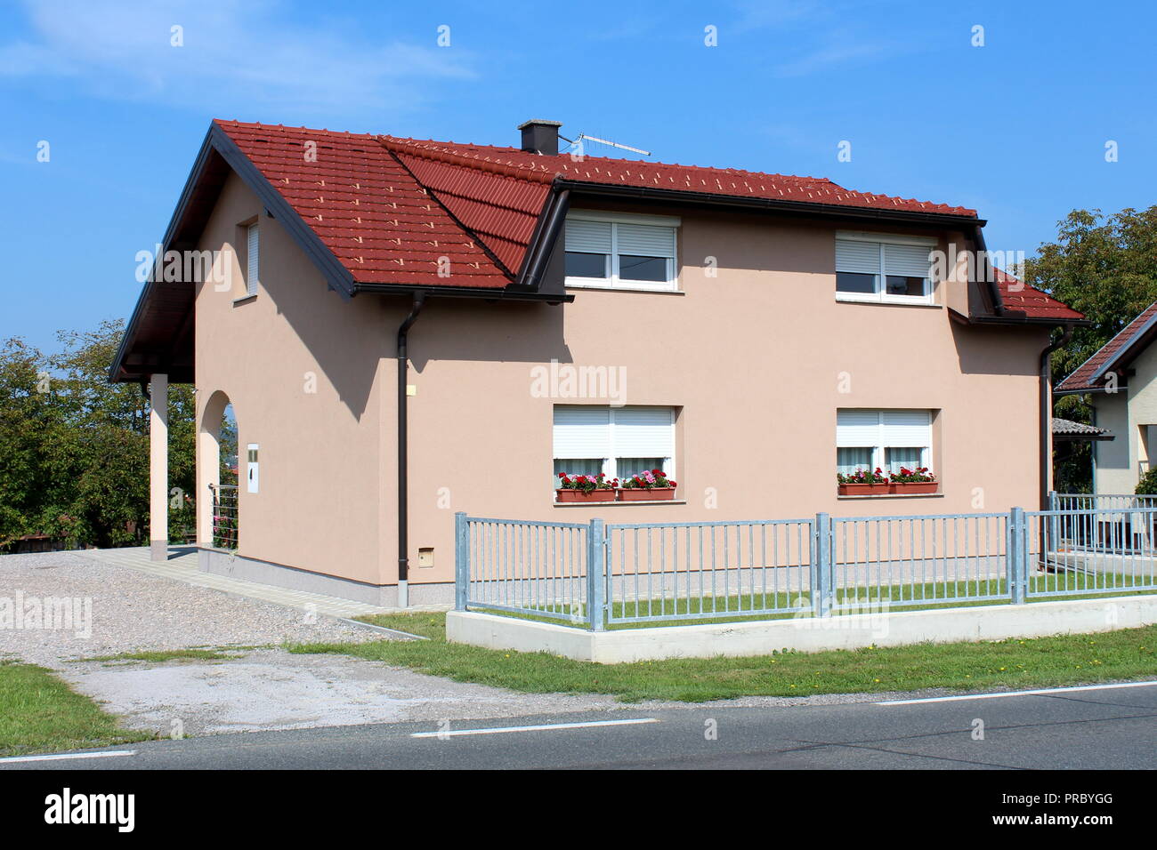 Fully renovated small suburban family house with new facade, white windows with fresh flowers ...