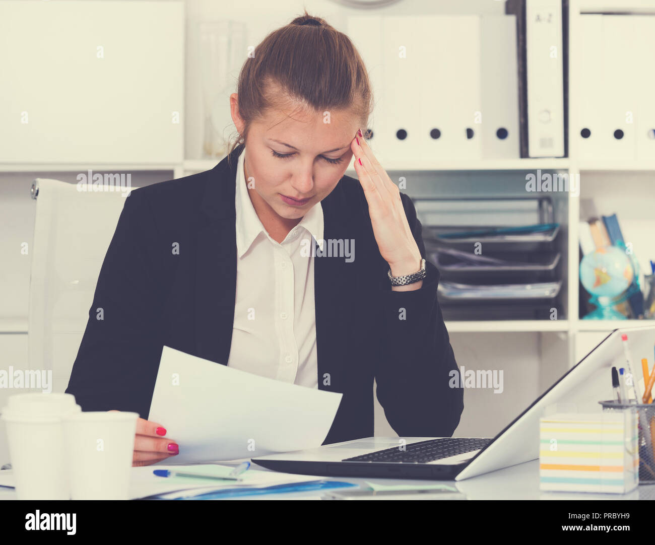 Woman in black suit is having complicated issue with project in office ...
