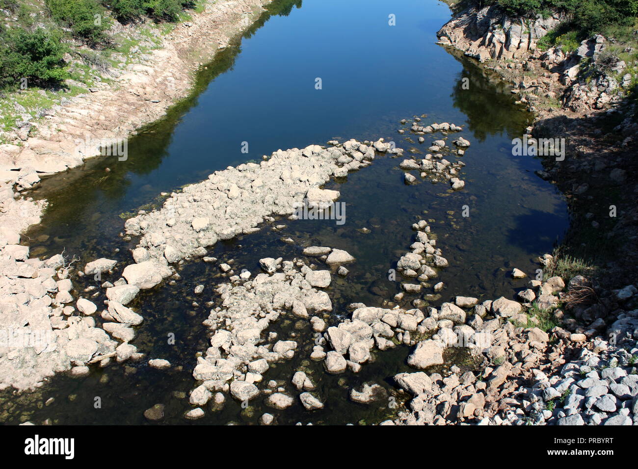 River with low summer water levels and visible rocks on river bottom ...