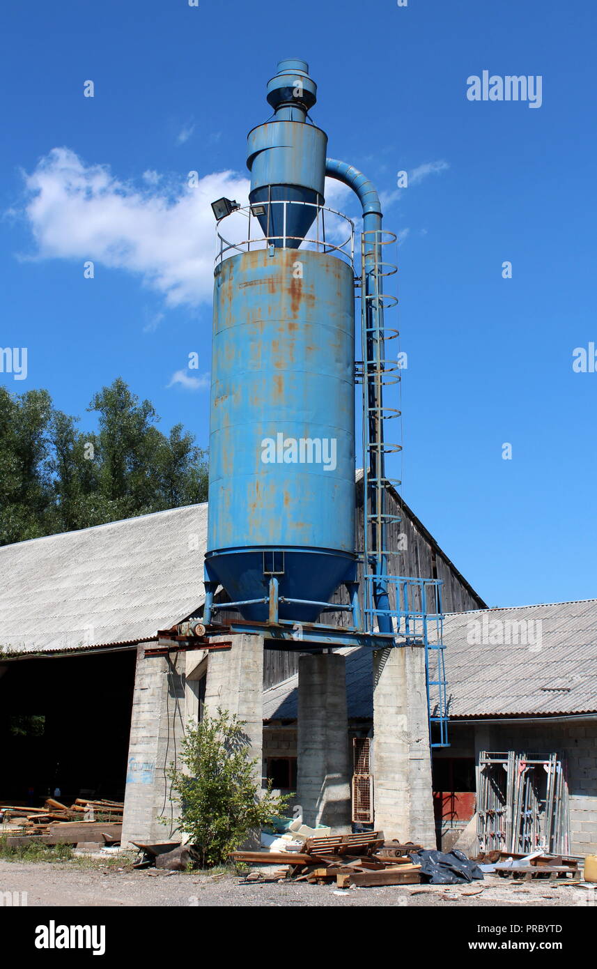 Rusted metal blue silo with safety stairs on side and reflector on top ...