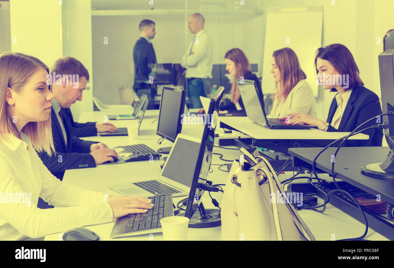 Successful people engaged in business activities in busy open plan ...