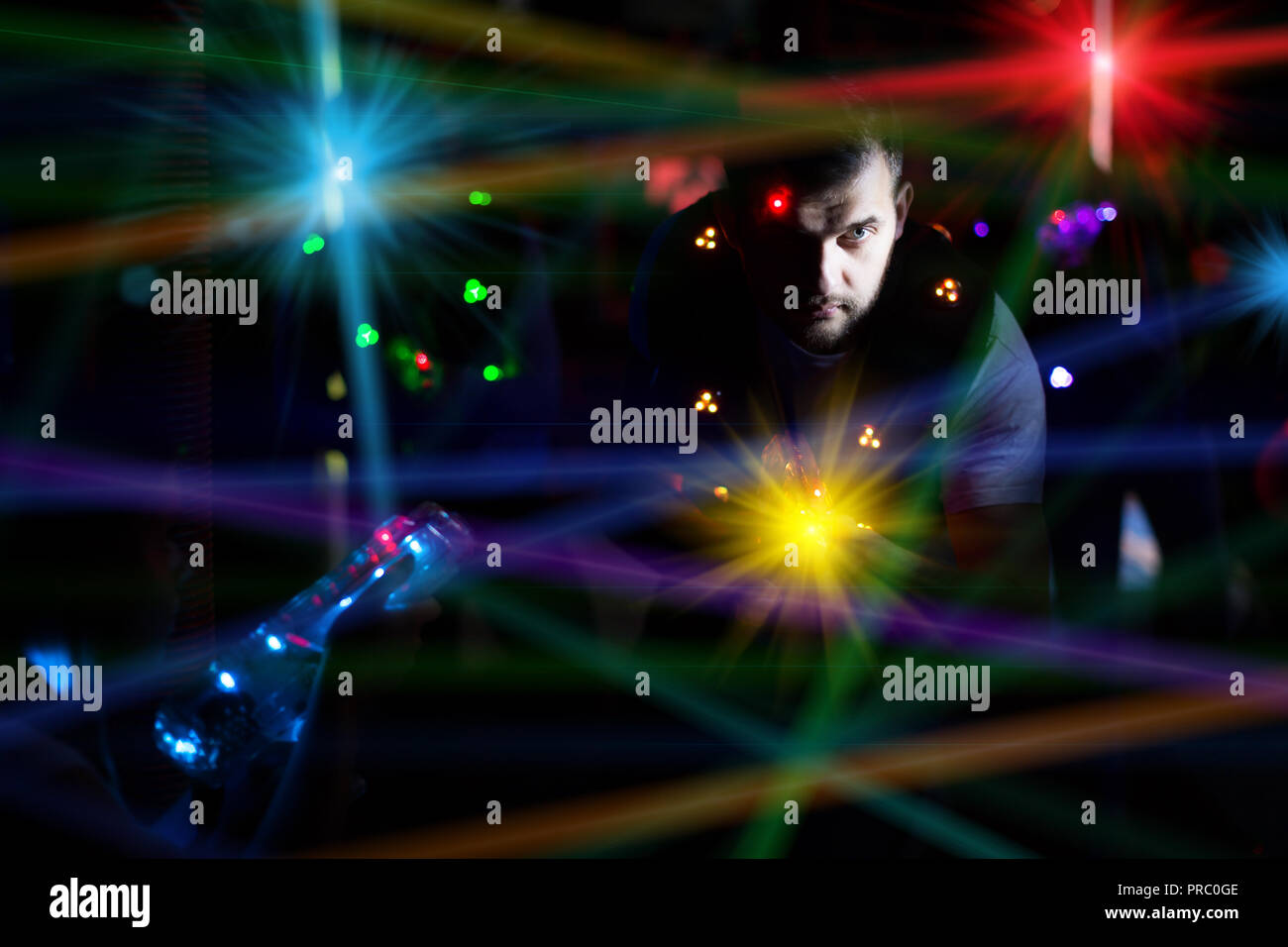 Portrait of excited guy laser tag player with laser pistol in room with ...