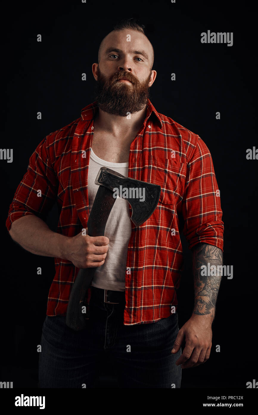 bearded male holding axe on chest and posing in studio Stock Photo - Alamy