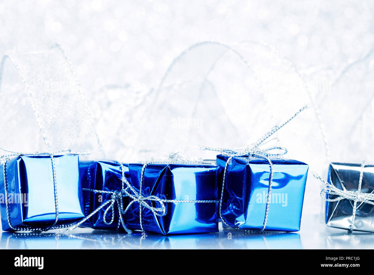 Decorative blue boxes with holiday gifts on shiny glitter background ...