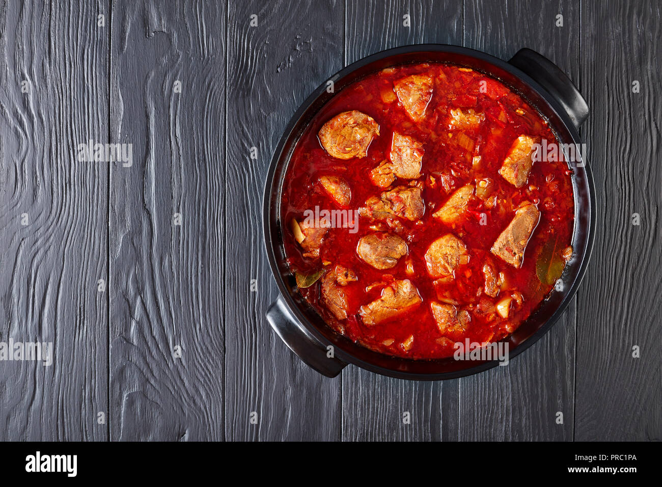 hot Red Chile and Pork Stew or Carne Adobada in a dutch oven on a black ...