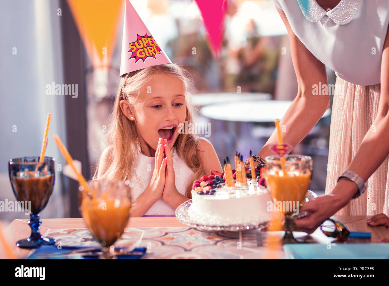 Impressed girl clapping her hands while looking at the beautiful cake ...