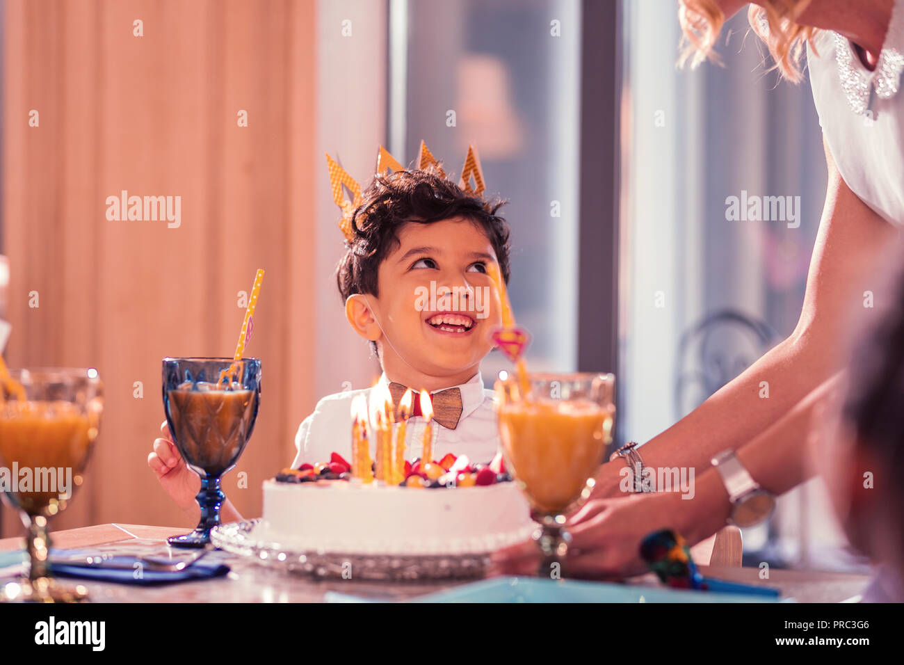 Positive little boy having birthday party and wearing paper crown Stock ...