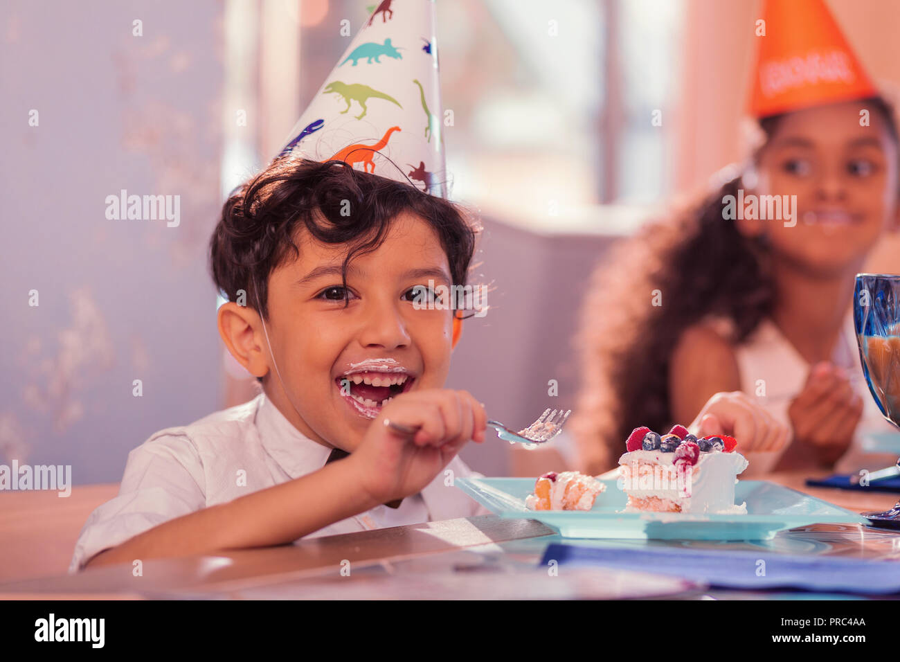 Emotional boy eating cake and laughing at the party Stock Photo - Alamy